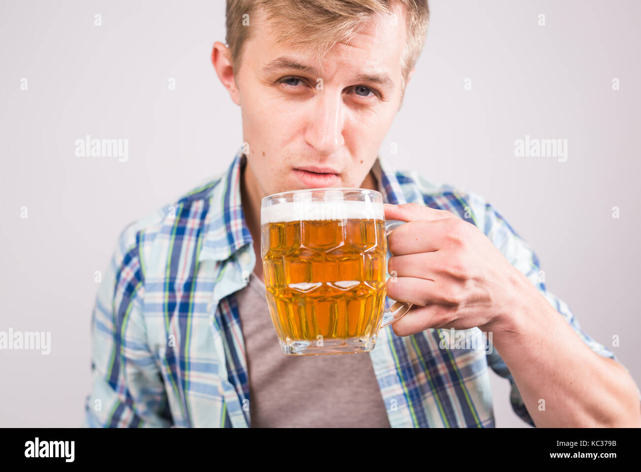 Man drinking beer. Happy young man holding a beer mug Stock Photo - Alamy