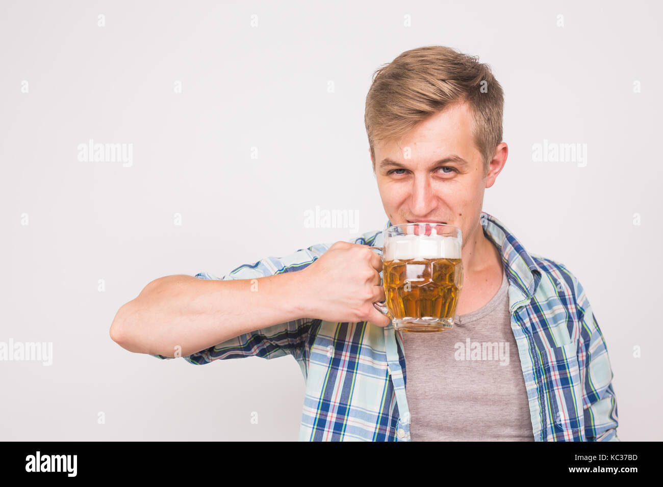 Man drinks beer. Handsome young guy drinking lager pint on white ...