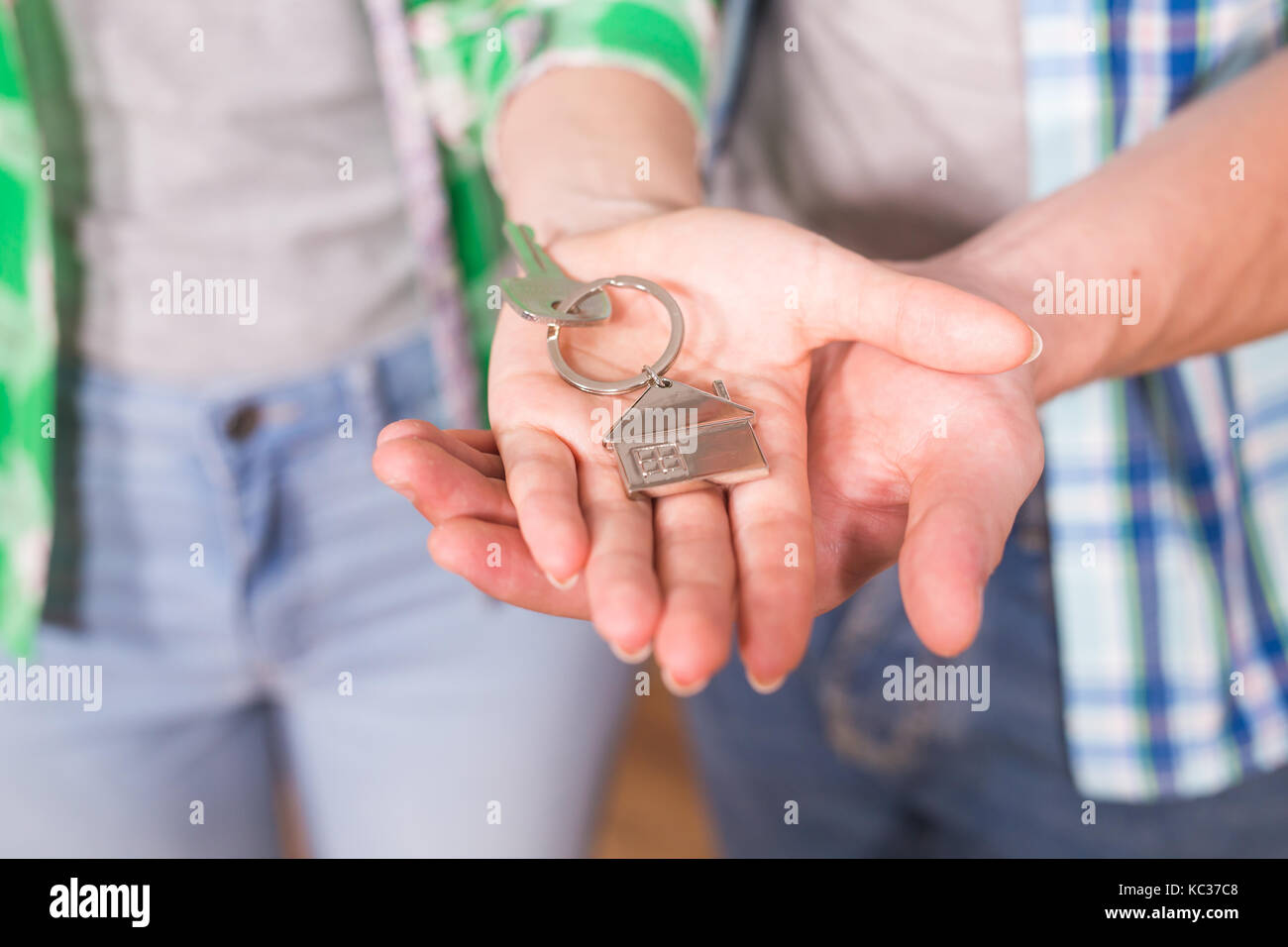 Female and male hands holding key house shaped keychain Stock Photo - Alamy