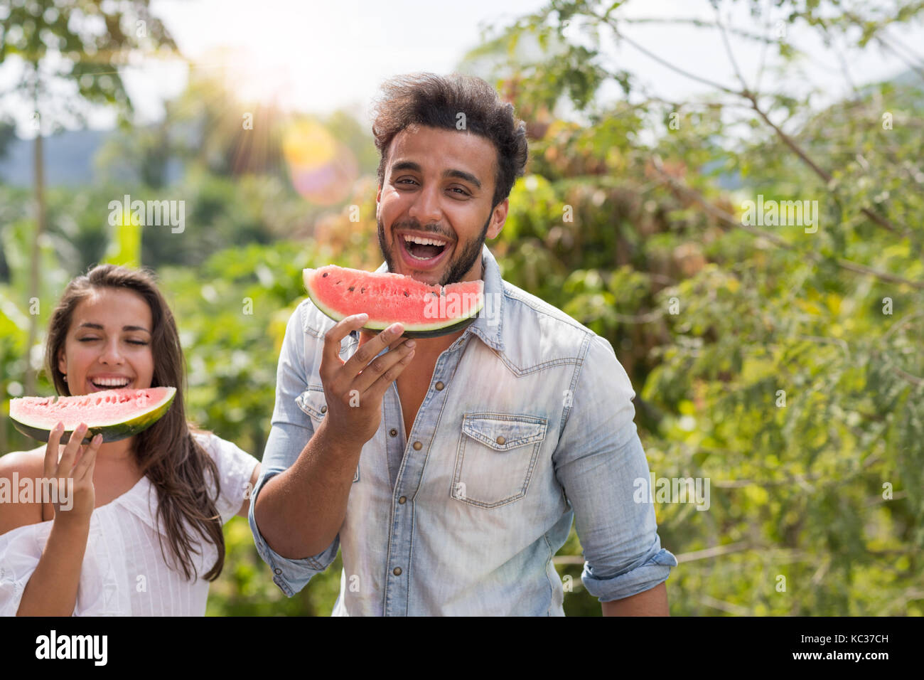 Happy Man And Woman Eating Watermelon Together Over Beautiful Tropical ...