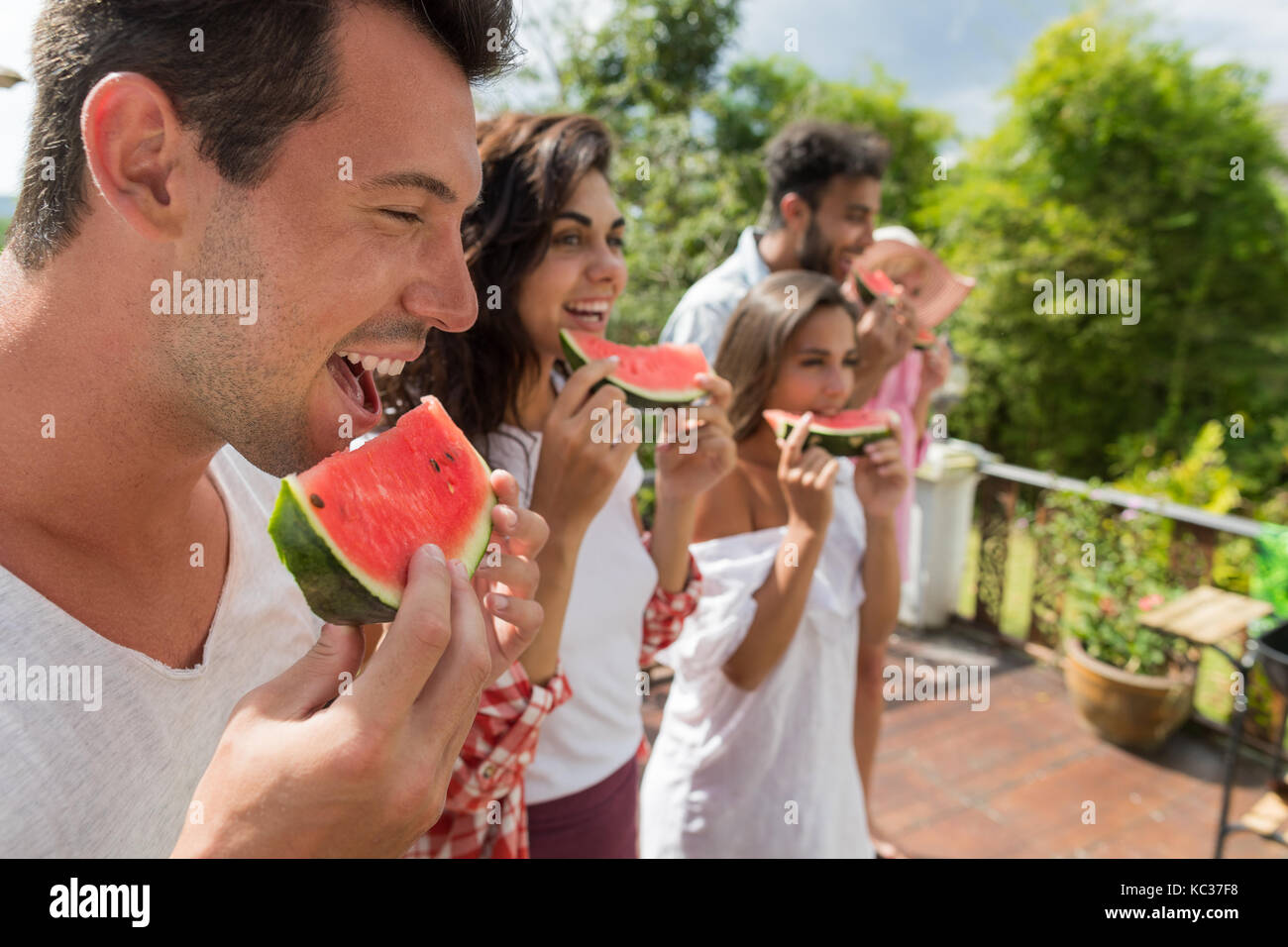 Side View Of Chherful Group Of People Eating Watermelon Together Happy ...