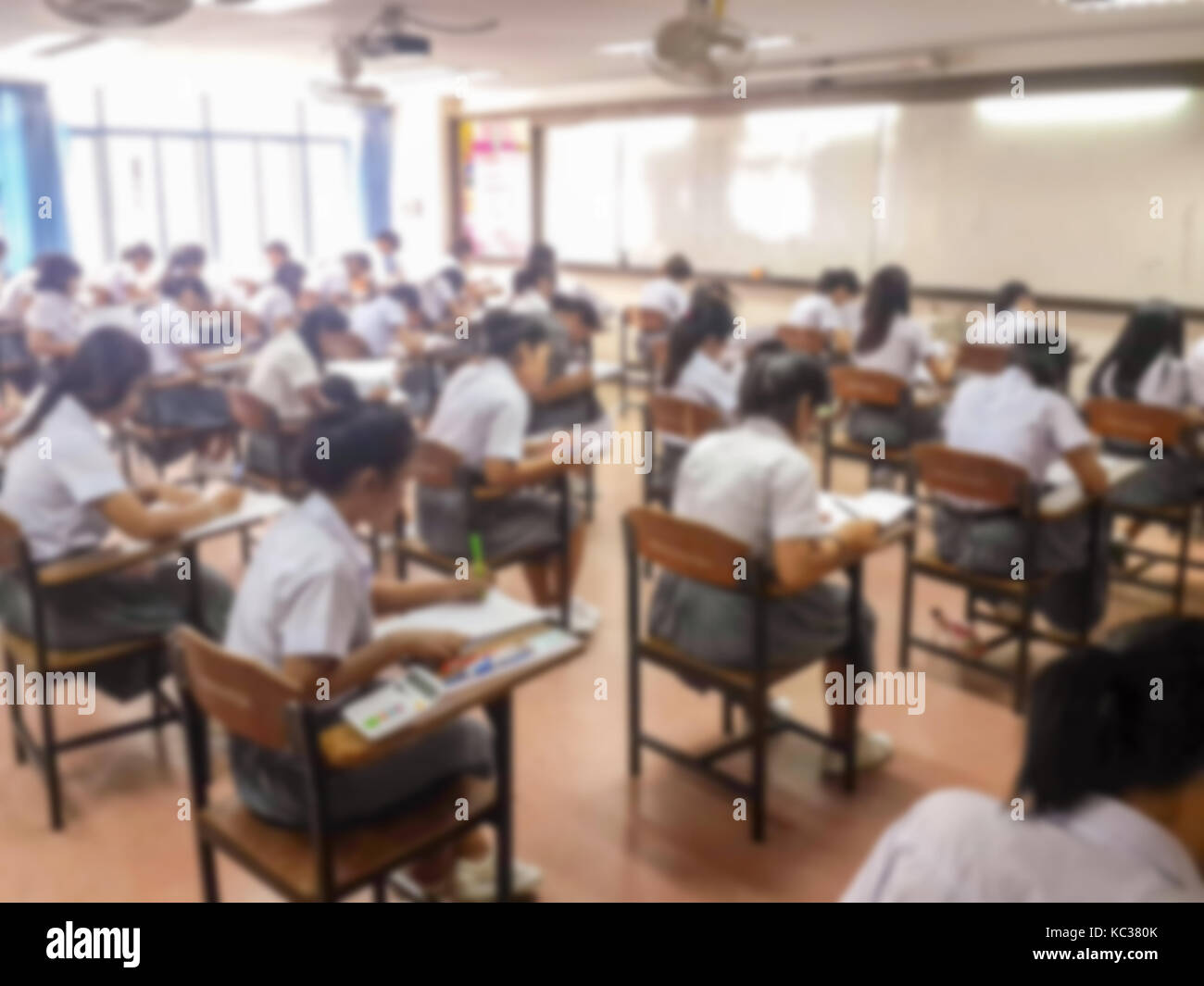 Blur school or university students writing answer doing exam in ...