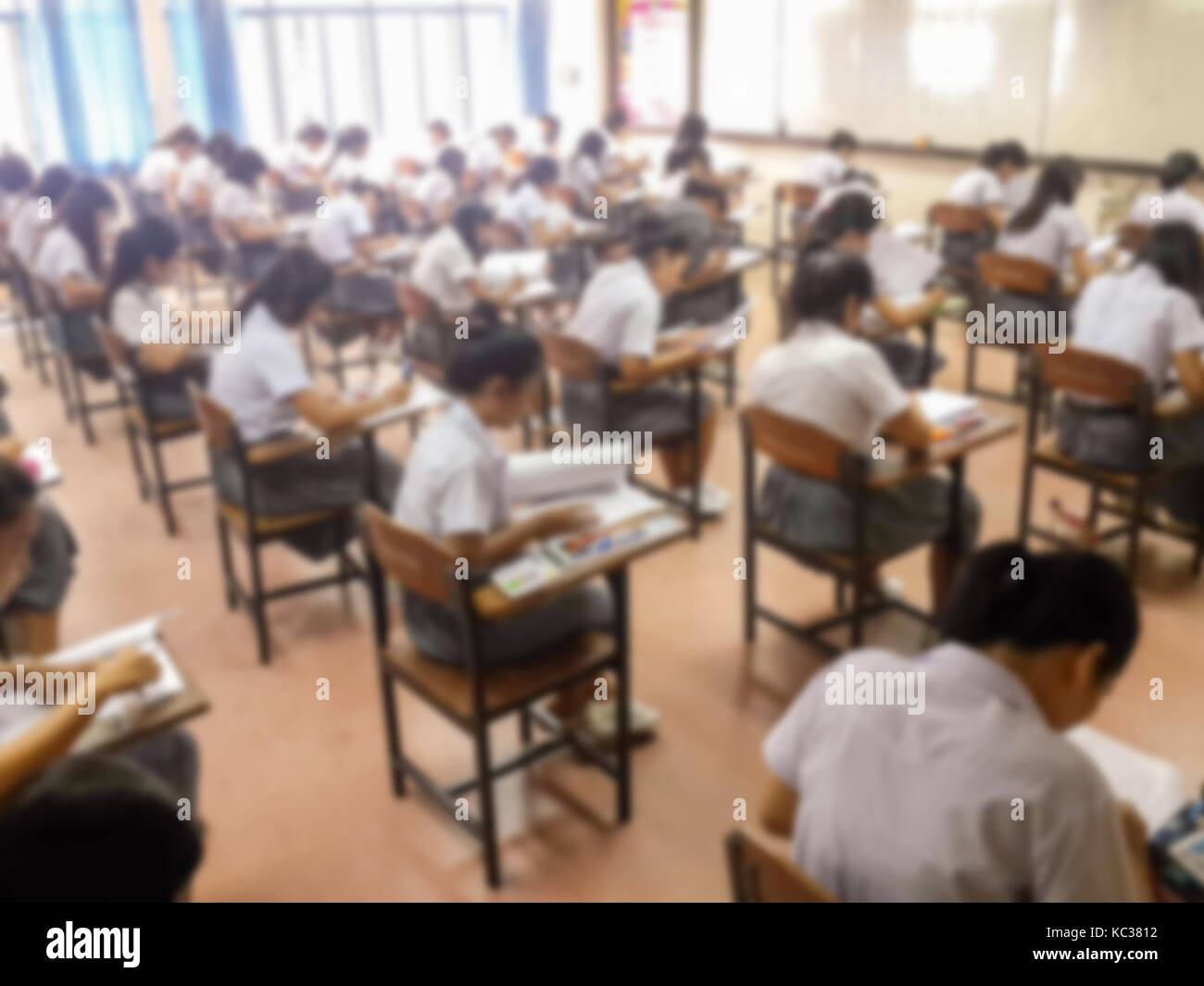Blur school or university students writing answer doing exam in ...