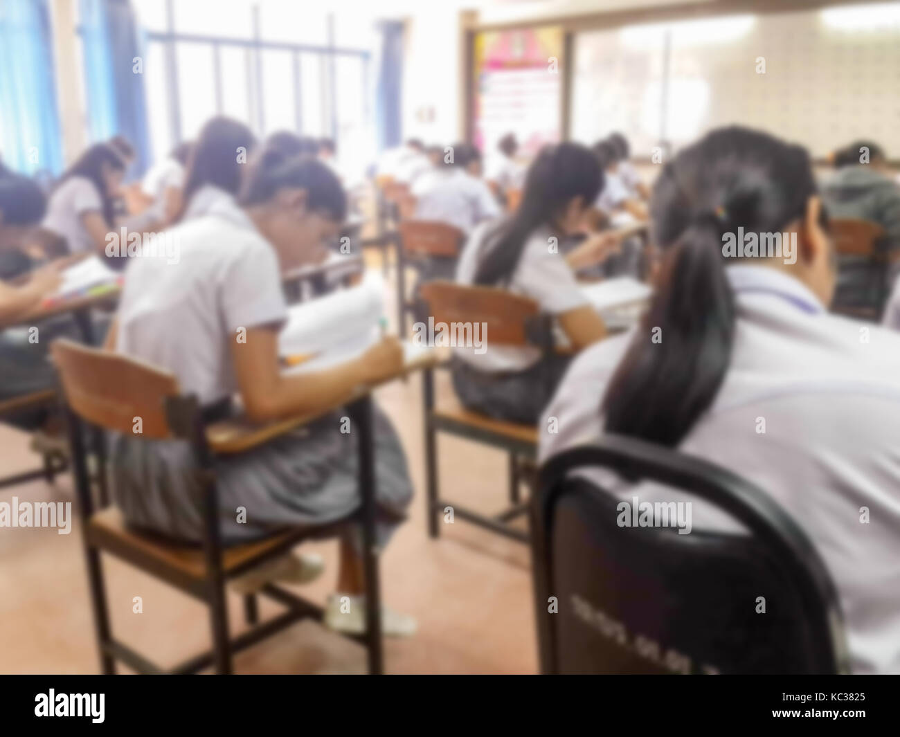 Blur school or university students writing answer doing exam in ...