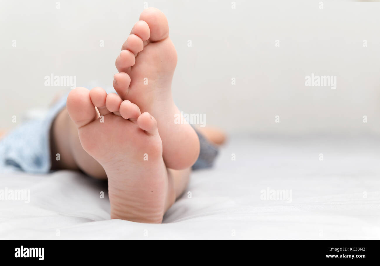 little girl's feet who sleeps in her bed closeup, comfort and ...