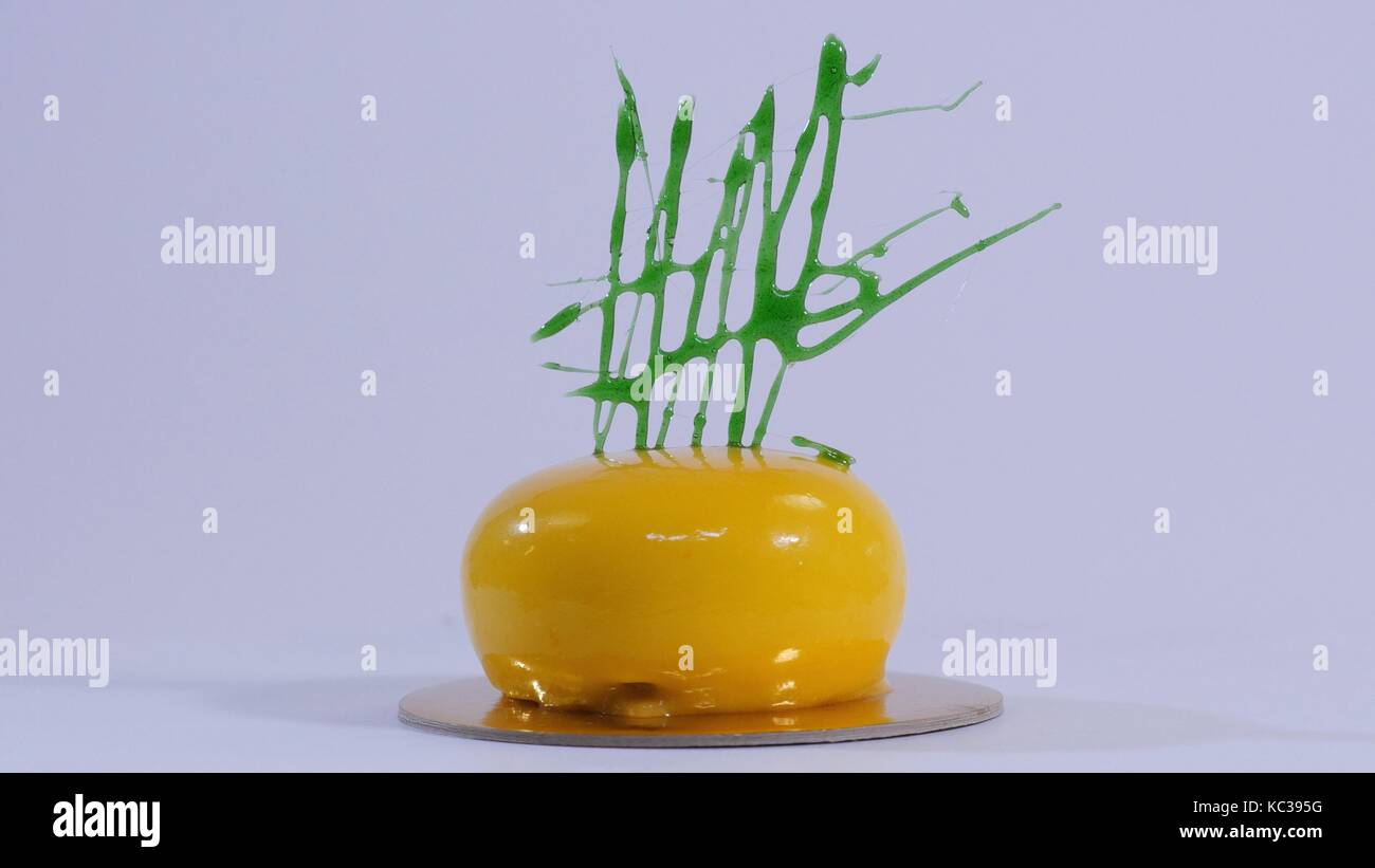 Contemporary Yellow Mousse Cake decorated with green caramel, on white ...