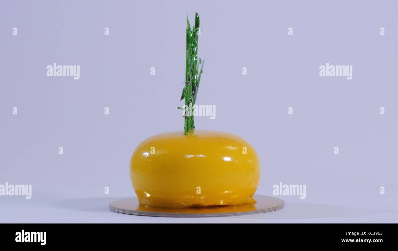 Contemporary Yellow Mousse Cake decorated with green caramel, on white ...