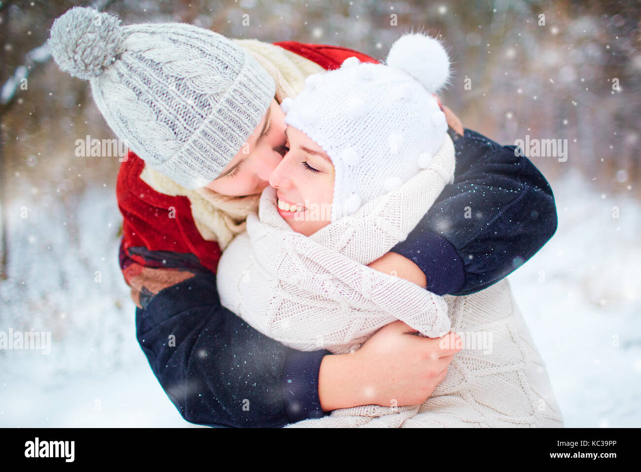 Young couple hugging on snow in winter park Stock Photo - Alamy