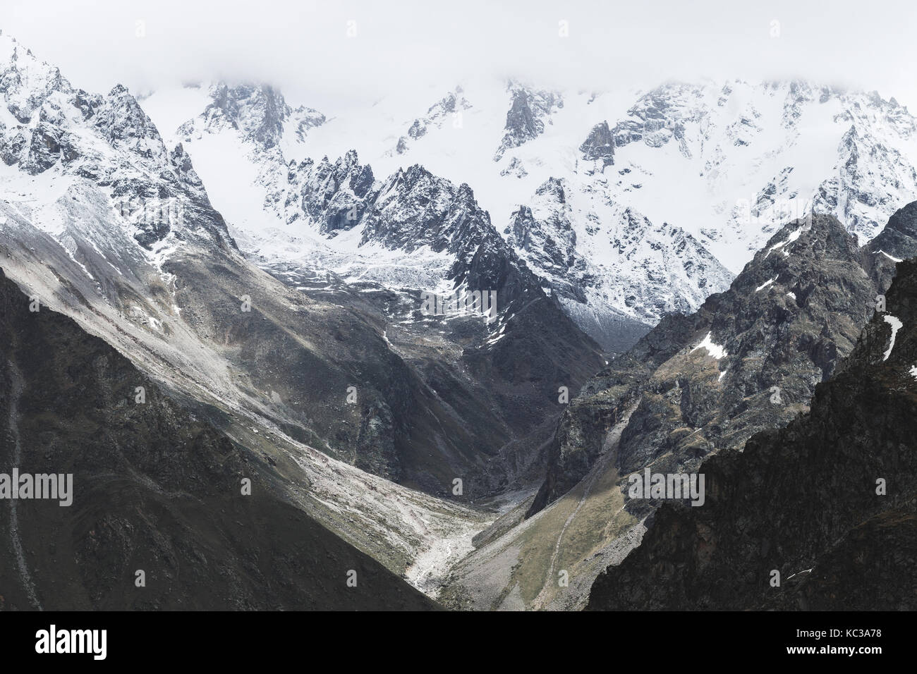 Snow mountain peaks of Caucasus mountains in cold cloudy weather ...