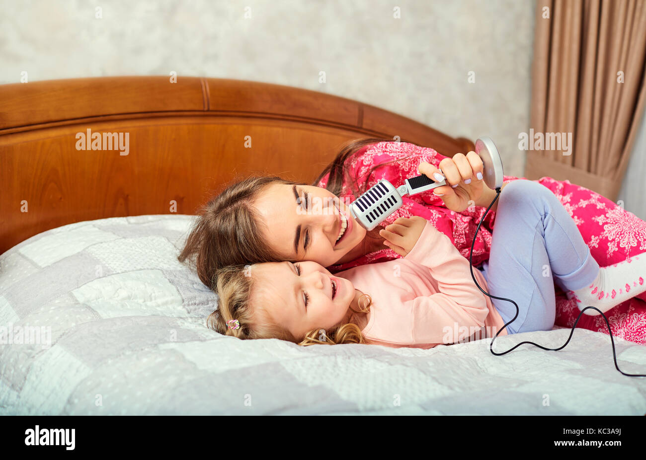 Mother and daughter sing fun together karaoke songs in the room Stock ...