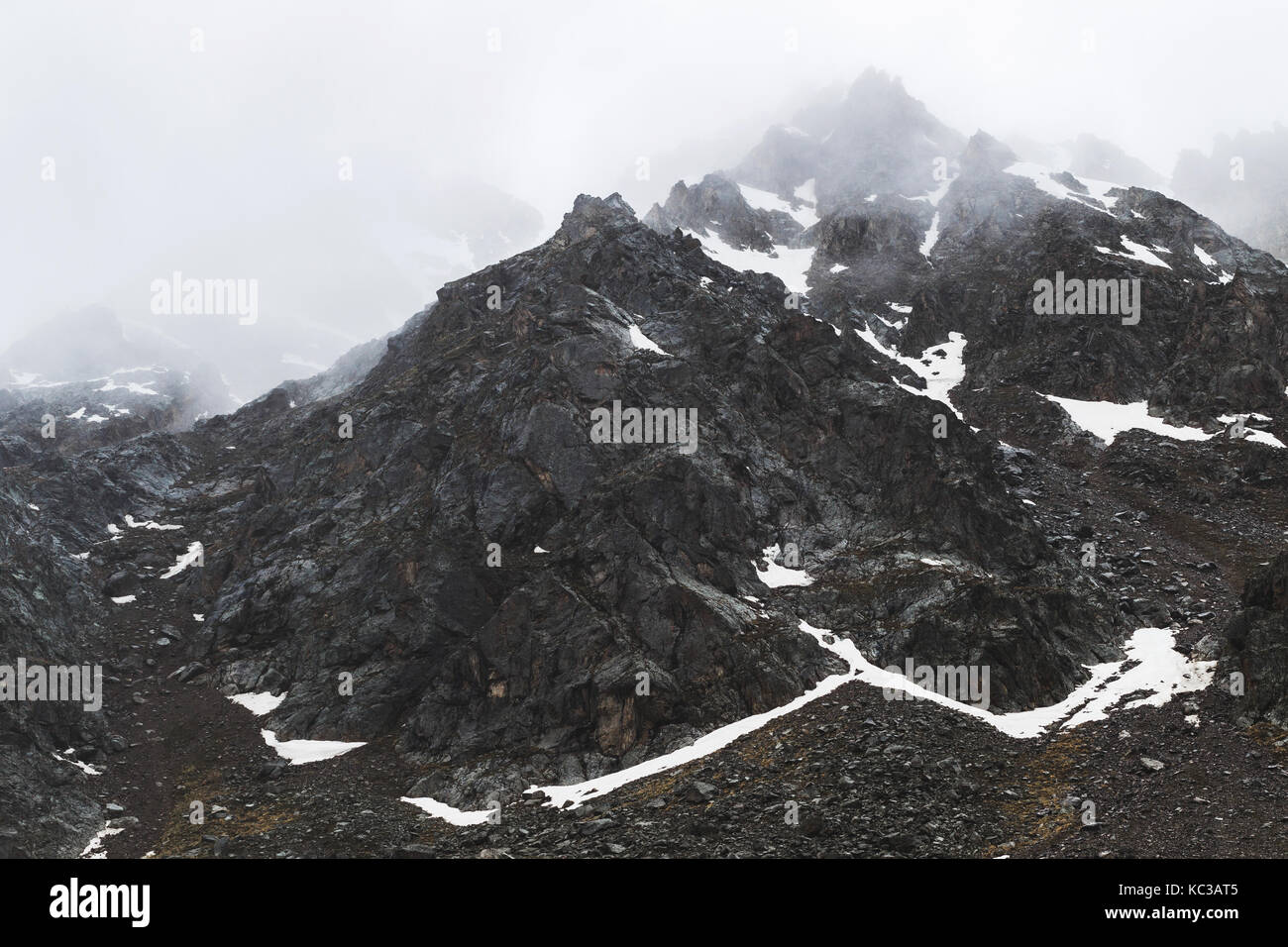 Mountain landscape with rocks and creeping fog. High peaks in the ...