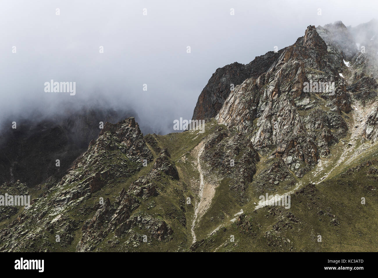 Mountain landscape with rocks and creeping fog. High peaks in the ...
