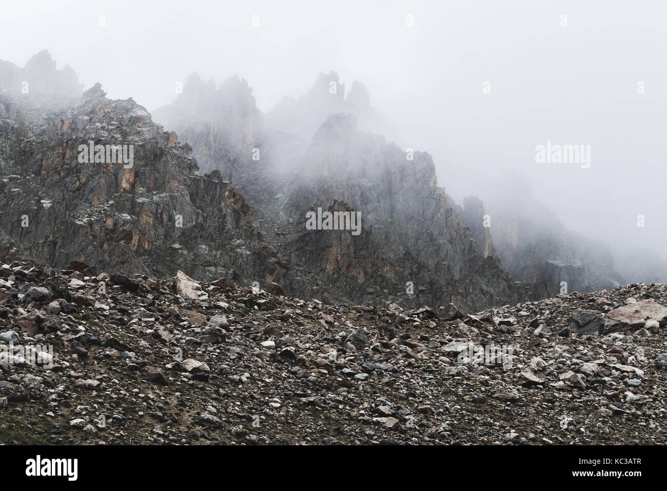 Mountain landscape with rocks and creeping fog. High peaks in the ...