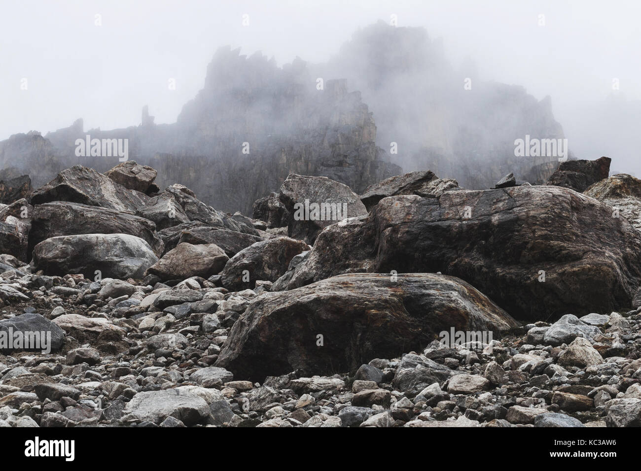 Mountain landscape with rocks and creeping fog. High peaks in the ...