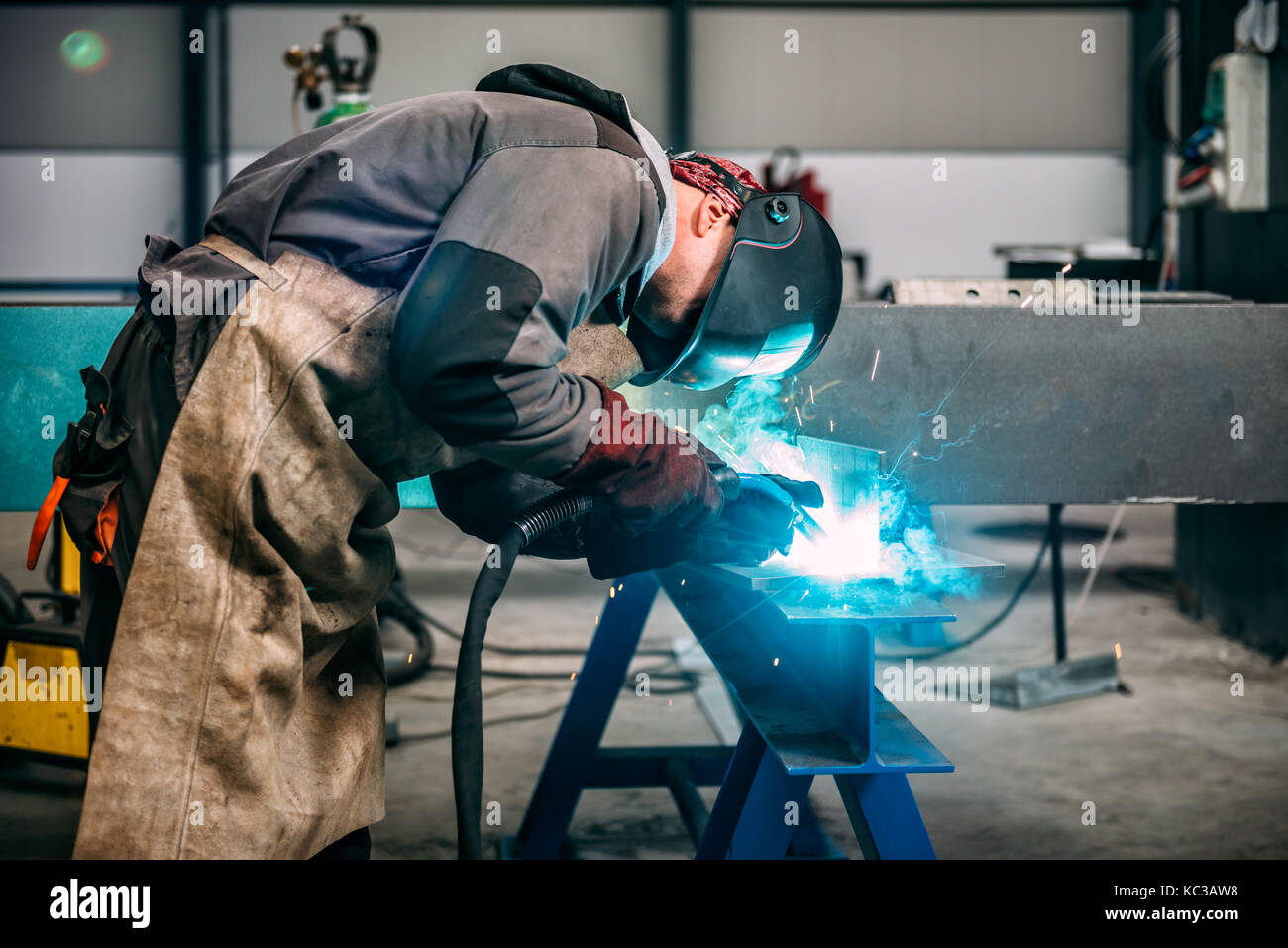 Industrial Welder With Torch and Protective Helmet in big hall welding ...