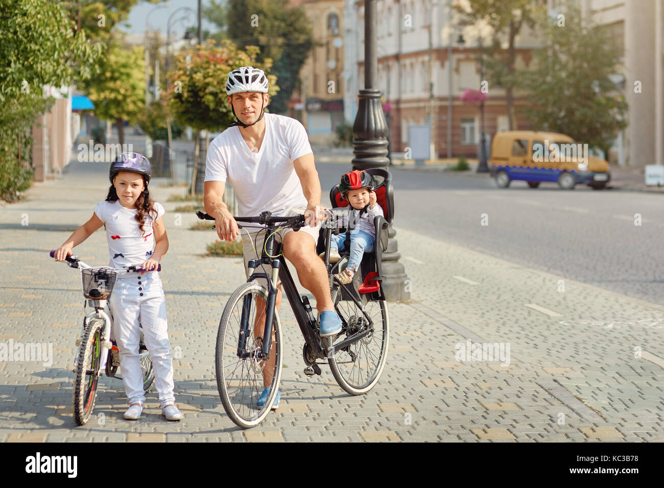 Cheerful family biking in park Stock Photo - Alamy