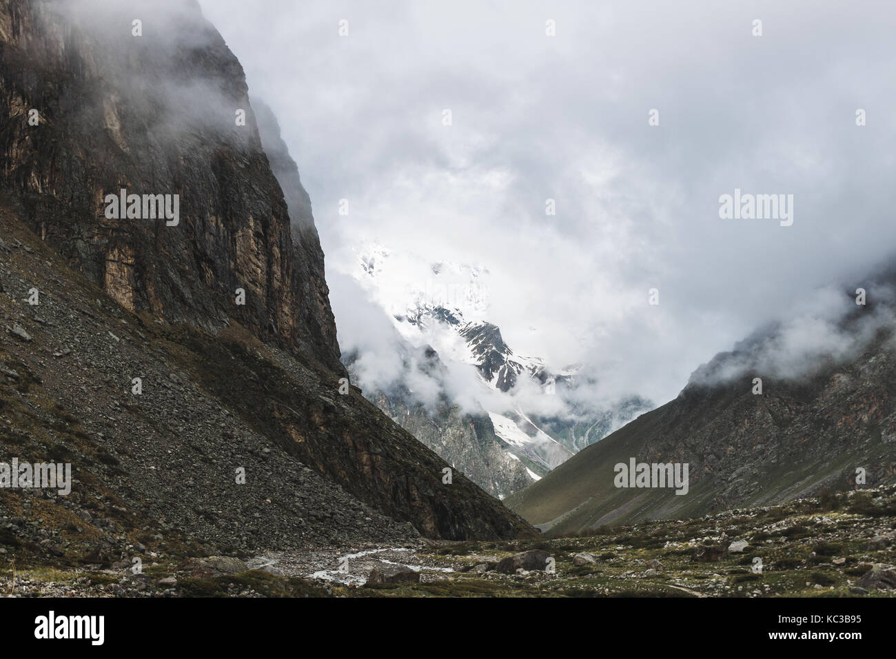 Mountain landscape with rocks and creeping fog. High peaks in the ...