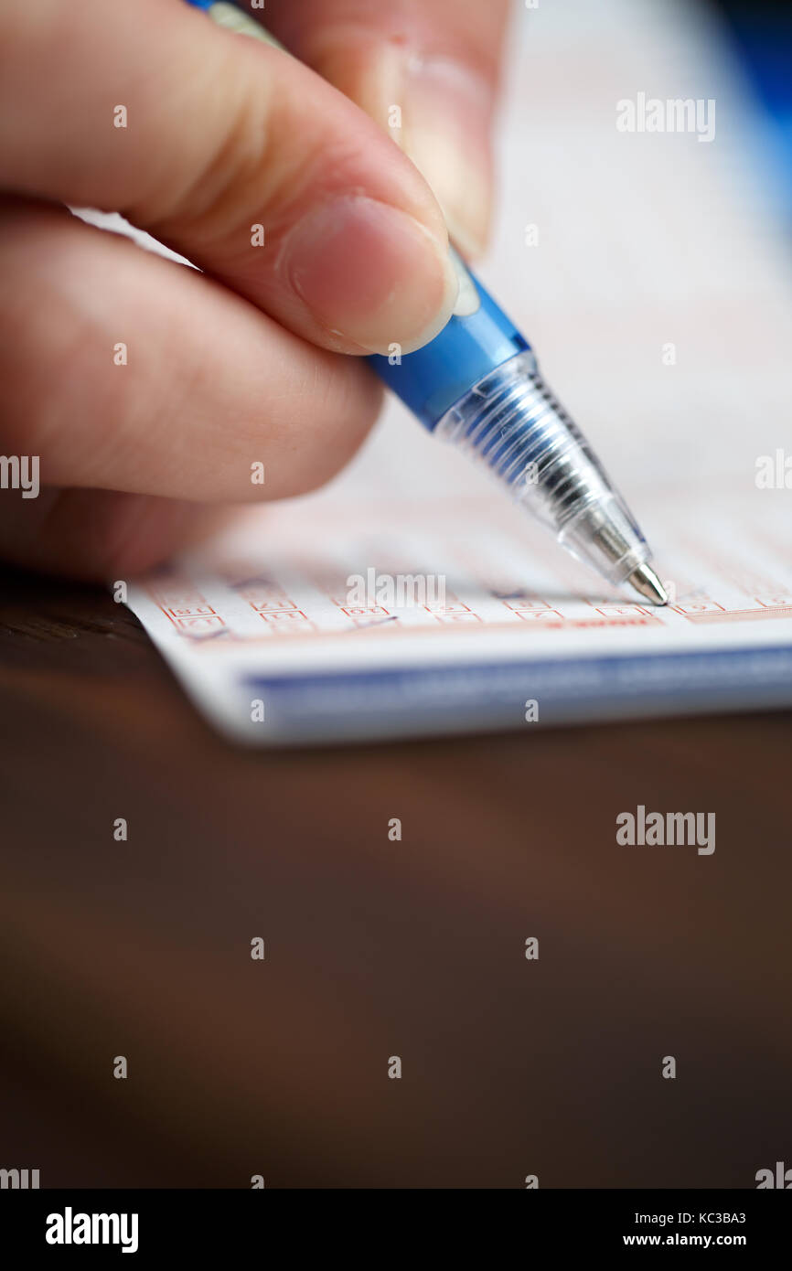 Picture of person writing in lottery ticket Stock Photo - Alamy