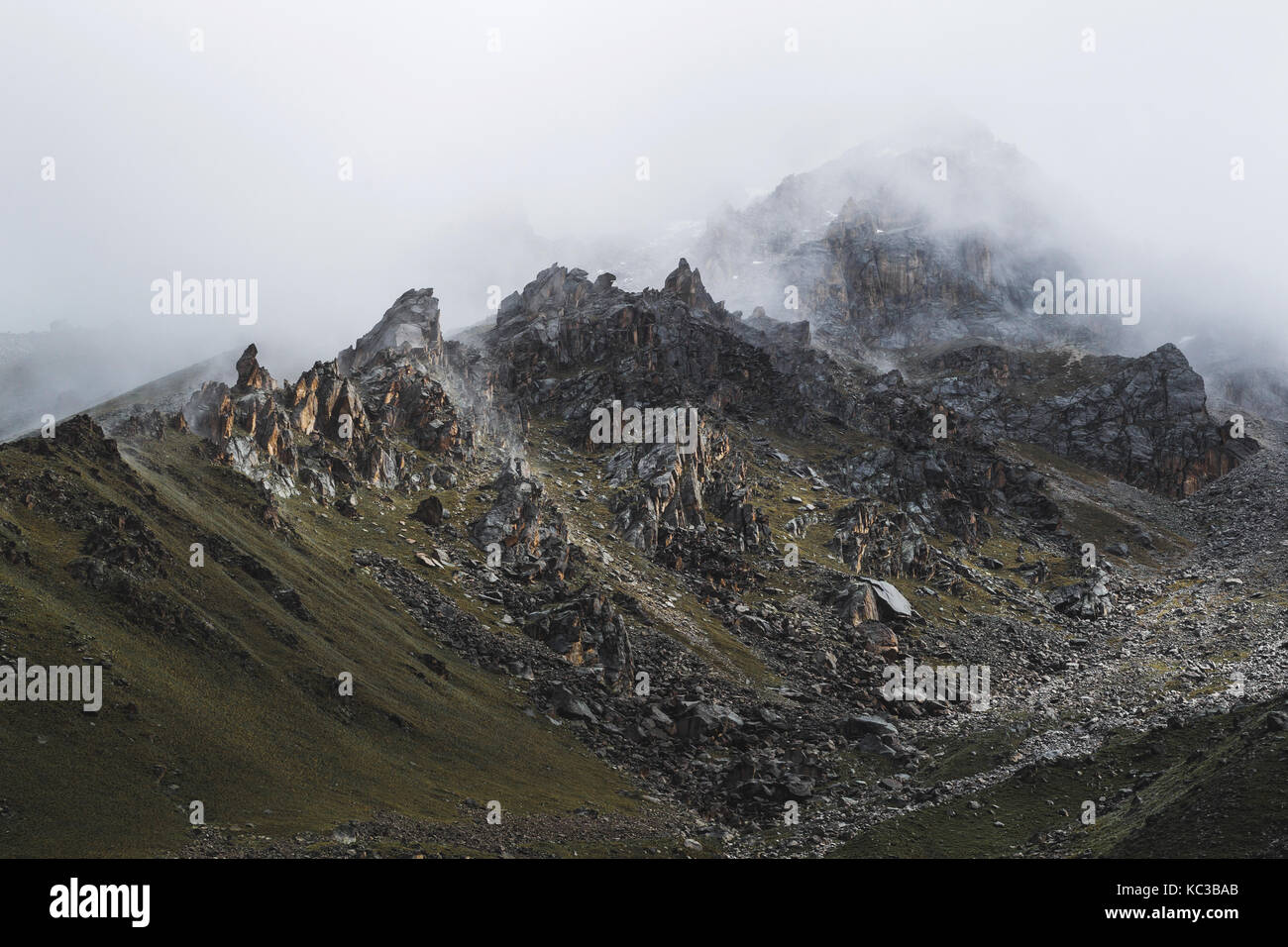 Mountain landscape with rocks and creeping fog. High peaks in the ...