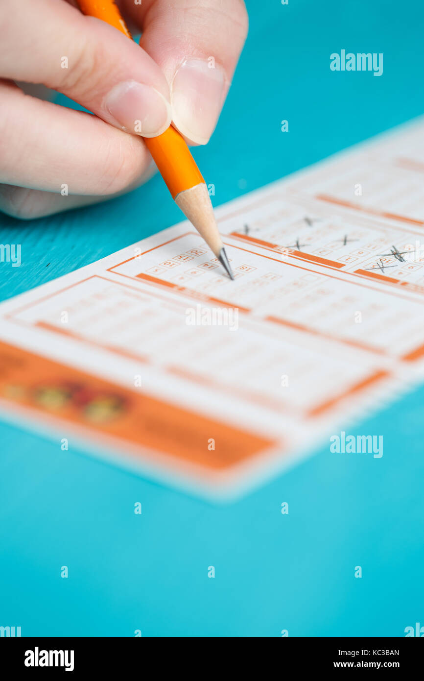Close-up image of man's hand with pencil , lottery ticket Stock Photo ...