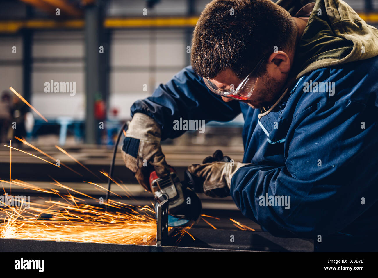 Worker Using Angle Grinder in Factory and throwing sparks Stock Photo ...