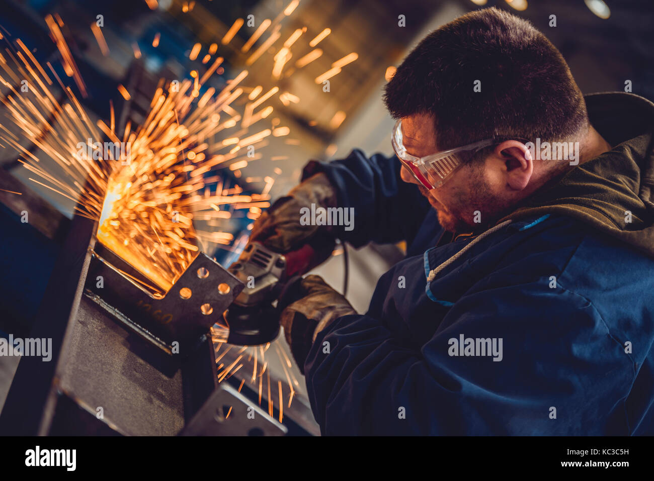 Worker Using Angle Grinder in Factory and throwing sparks Stock Photo ...