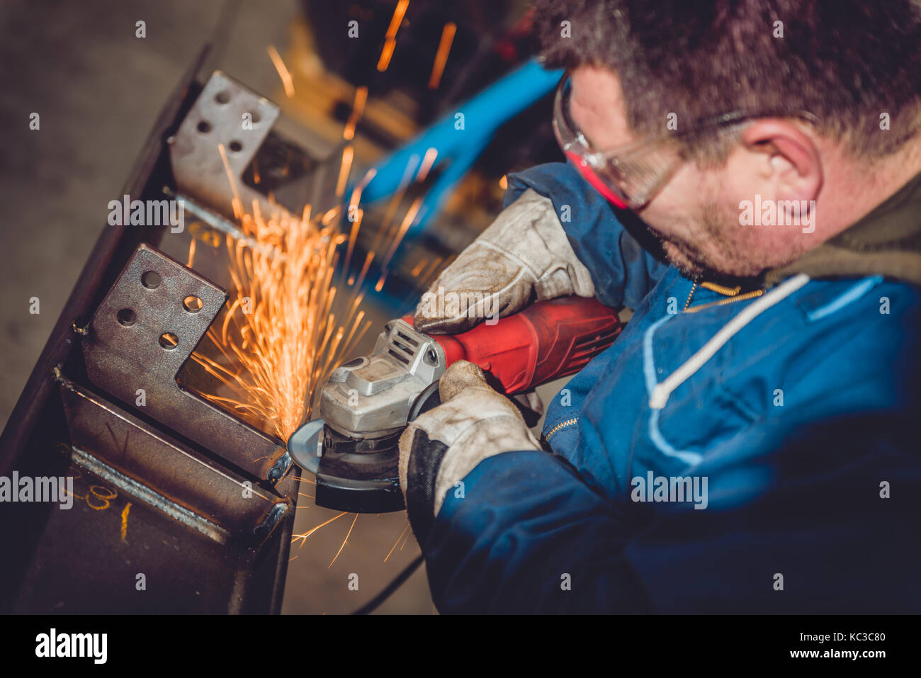 Worker Using Angle Grinder in Factory and throwing sparks Stock Photo ...