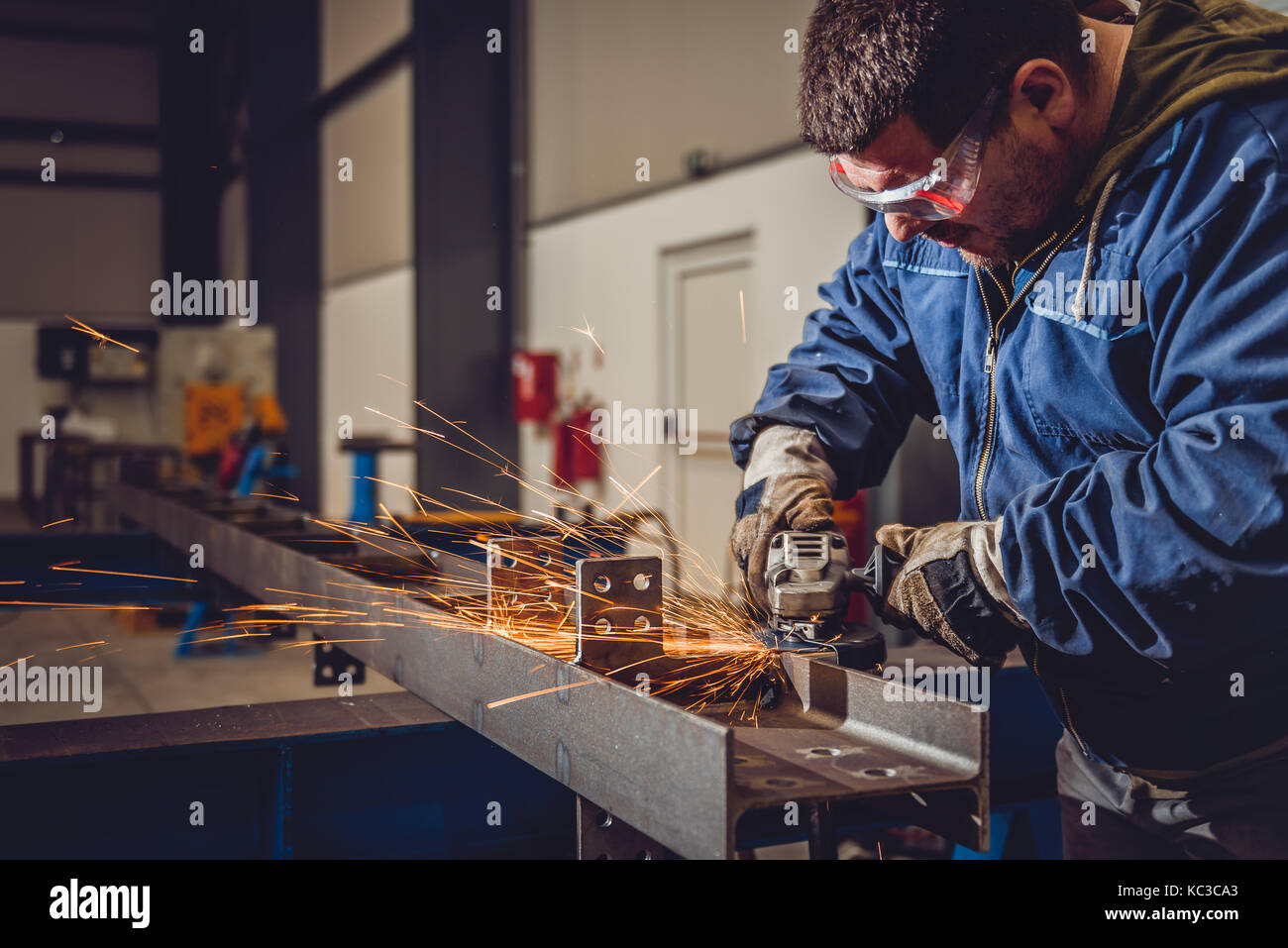 Worker Using Angle Grinder in Factory and throwing sparks Stock Photo ...