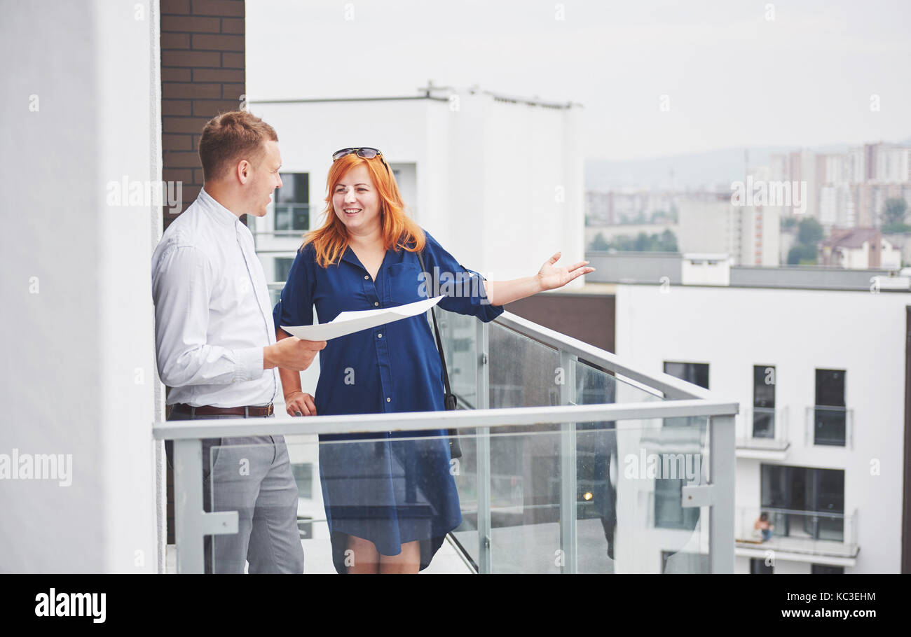 An engineer showing blueprint to her client Stock Photo - Alamy