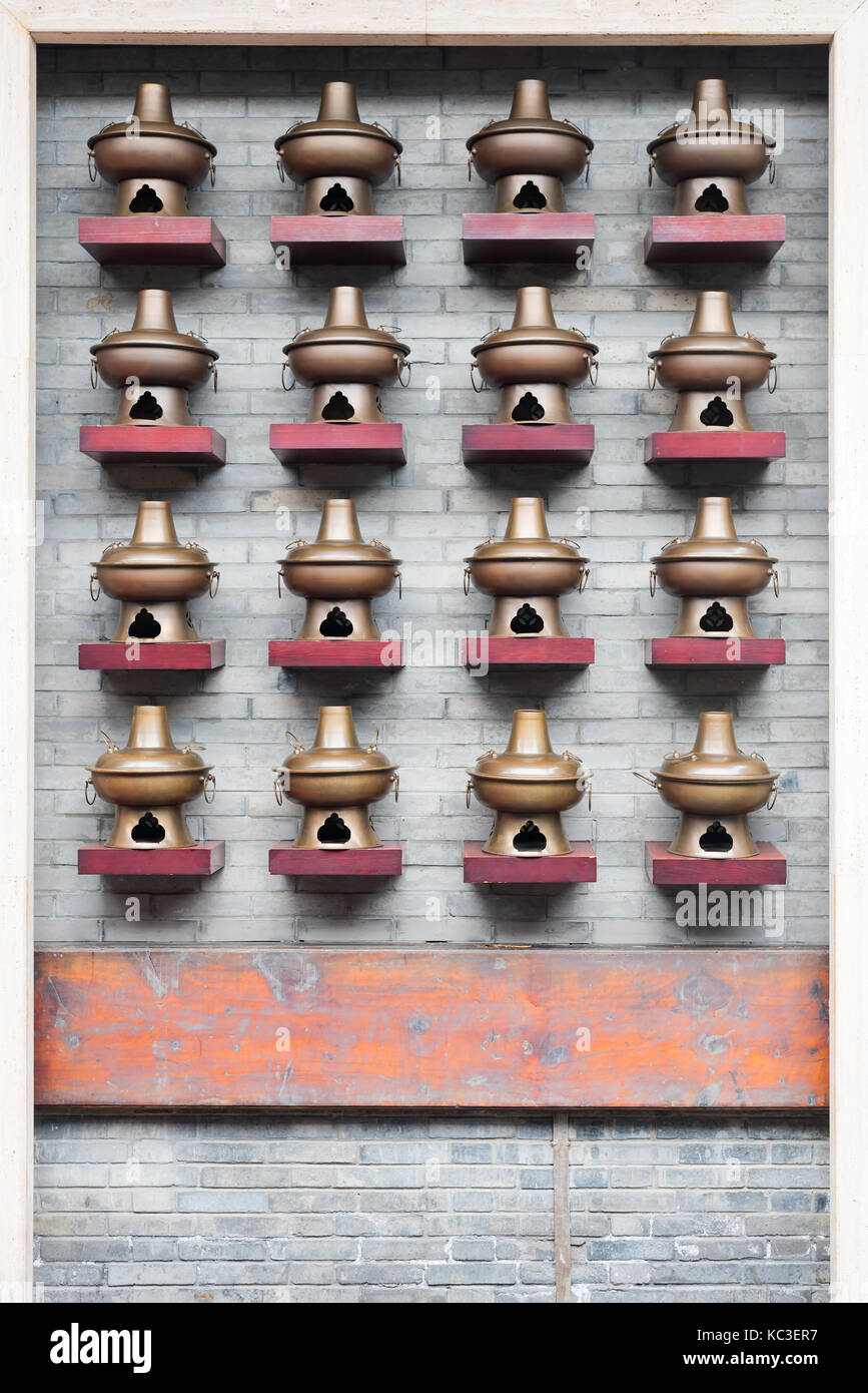 Bronze copper Hot-Pot decoration on a brick wall Stock Photo - Alamy