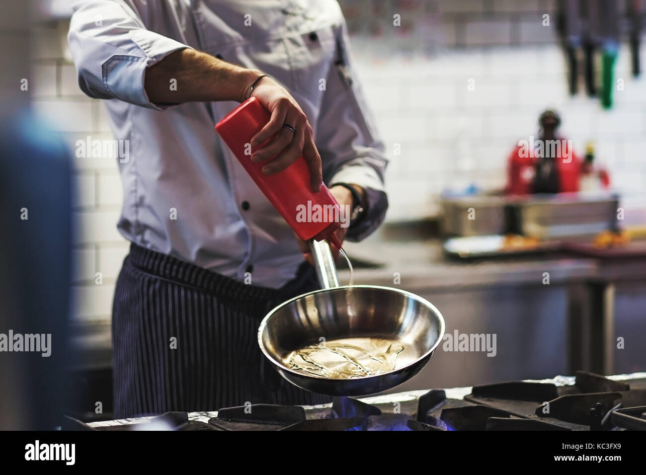 caucasian chef hand pours vegetable oil on a frying pan side view Stock ...