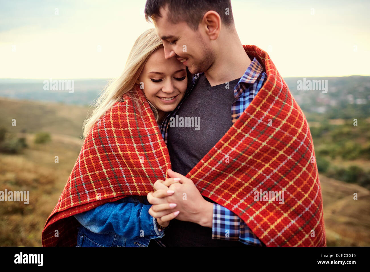 Happy couple under a plaid outdoors Stock Photo - Alamy