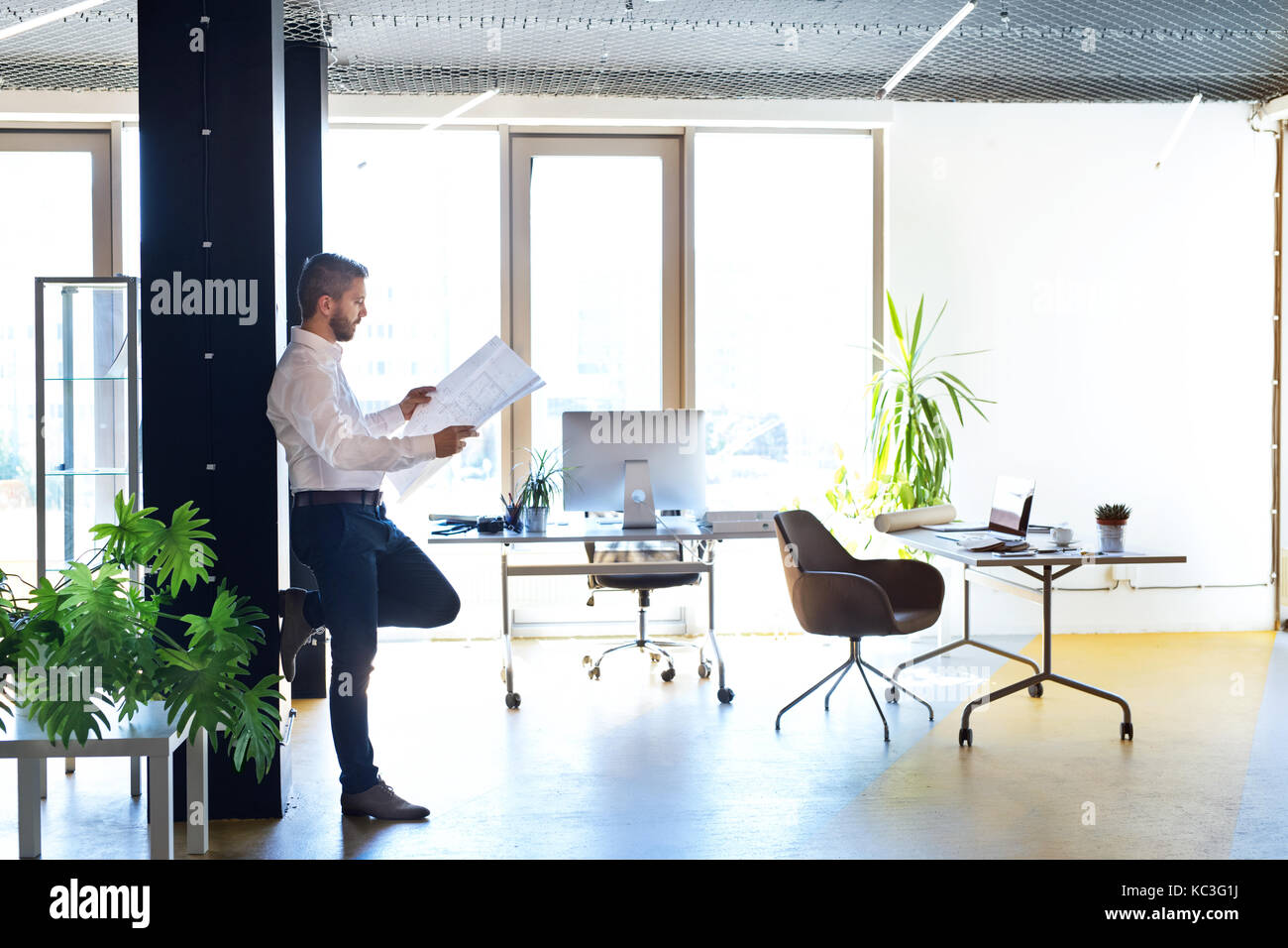 Young handsome businessman in his office studying plans Stock Photo - Alamy