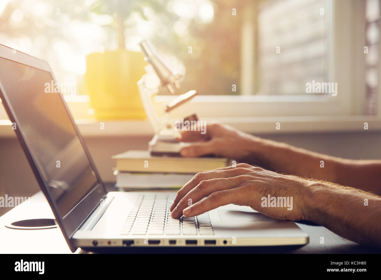 science education - new scientist working with laptop and microscope ...
