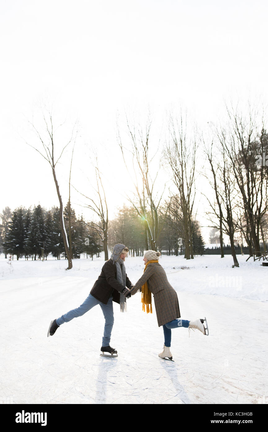 Senior couple in sunny winter nature ice skating Stock Photo - Alamy