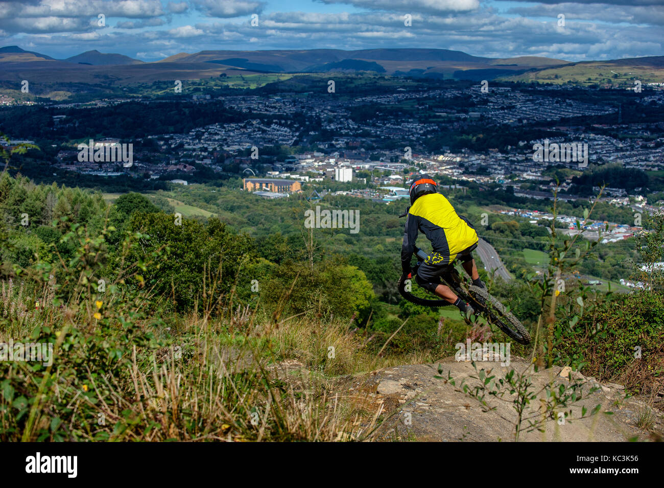 A mountain biker jumps while riding a trail at Bikepark Wales ...