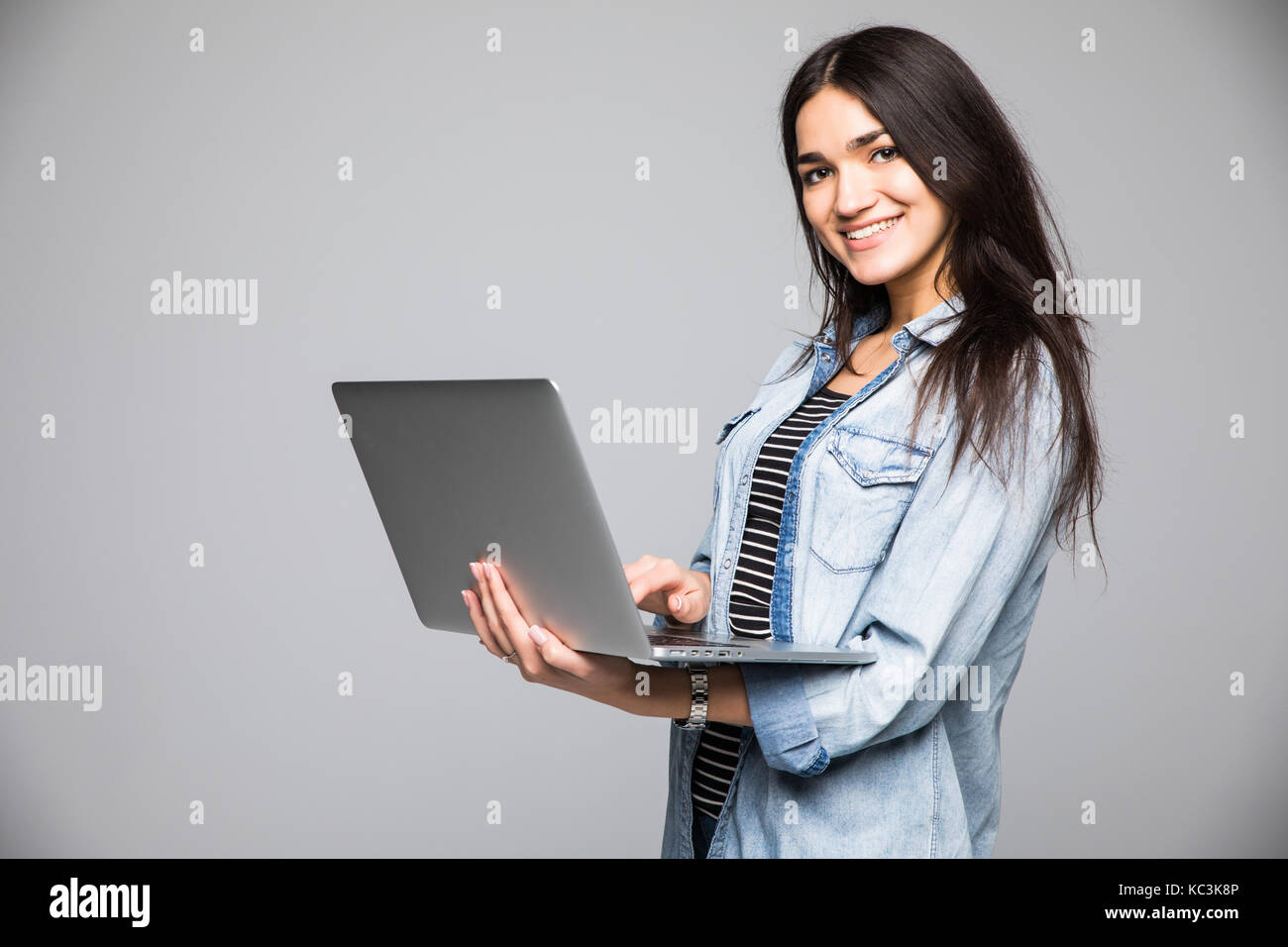Full length portrait of a smiling woman with laptop Stock Photo - Alamy
