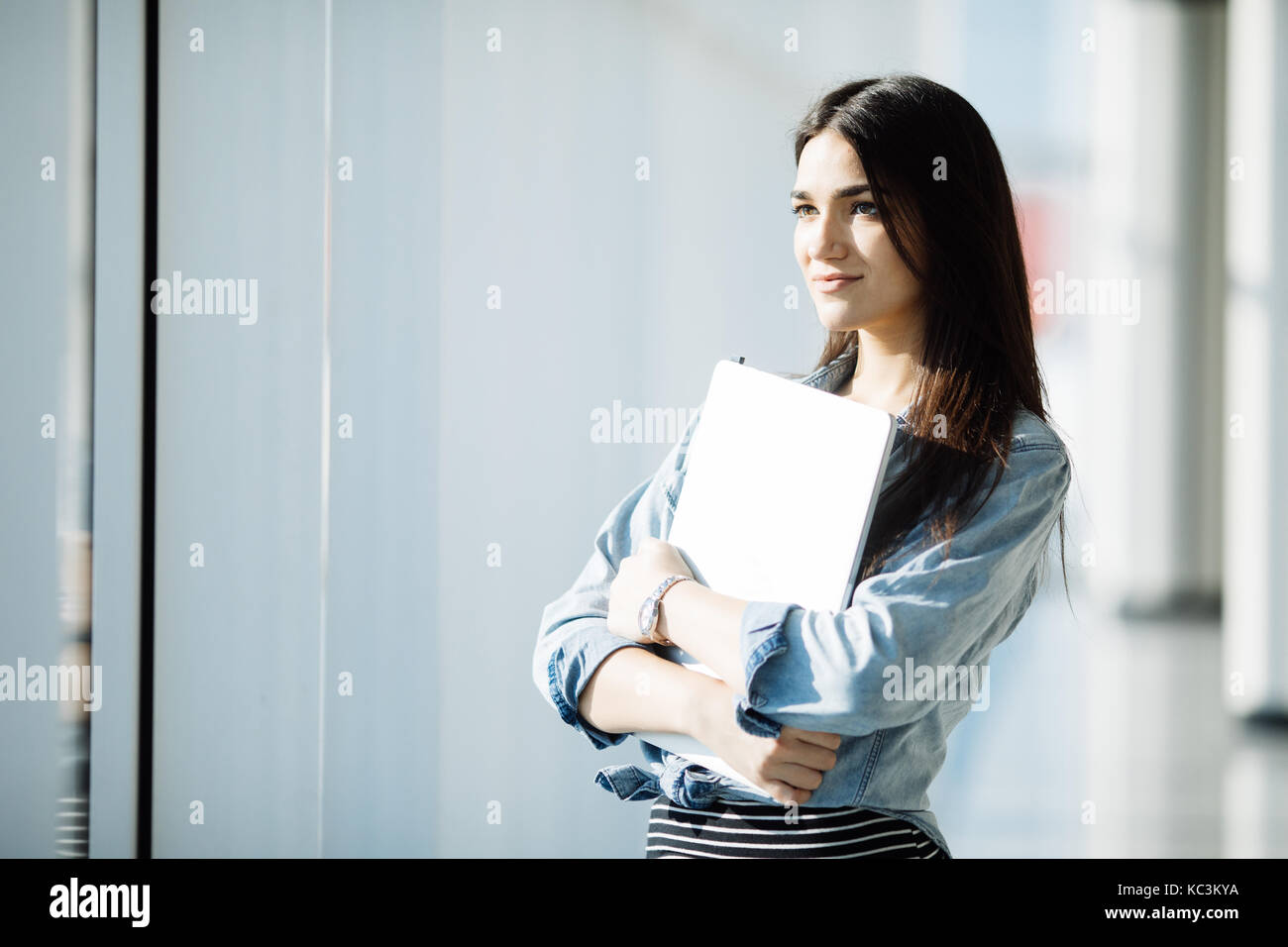 Successful female office worker with net-book is standing in skyscraper ...