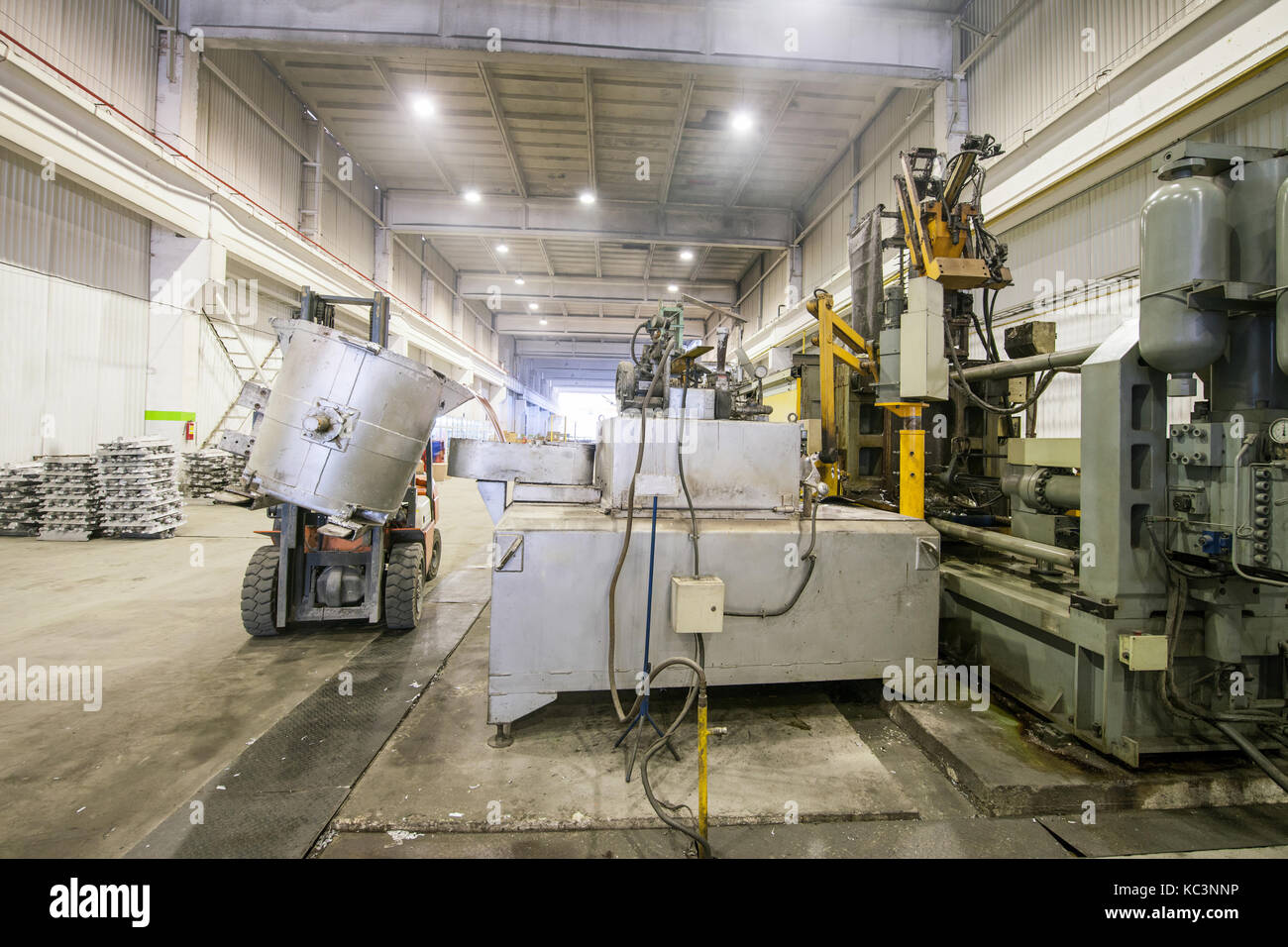 pouring the aluminum metal from the ladle to the loading machine in a ...