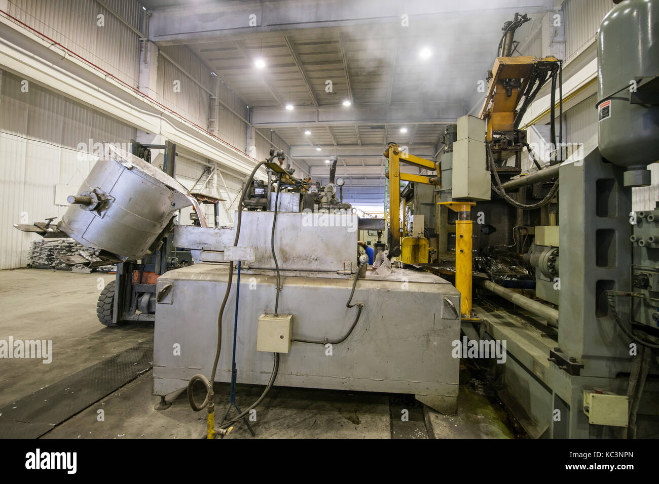 pouring the aluminum metal from the ladle to the loading machine in a ...