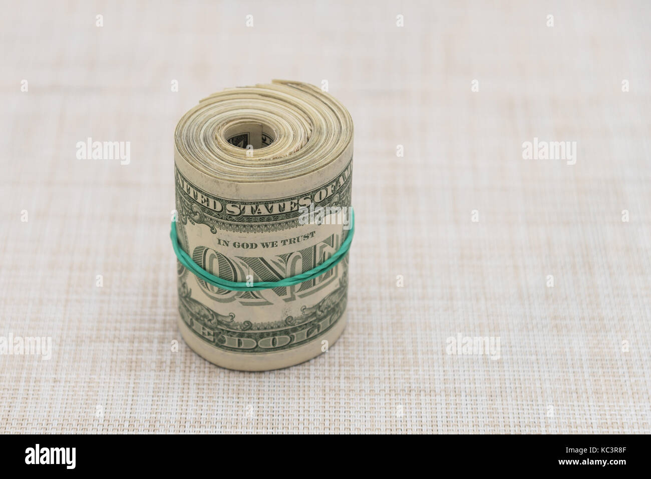 A bundle of money twisted into a bundle and bound by a green rubber ...