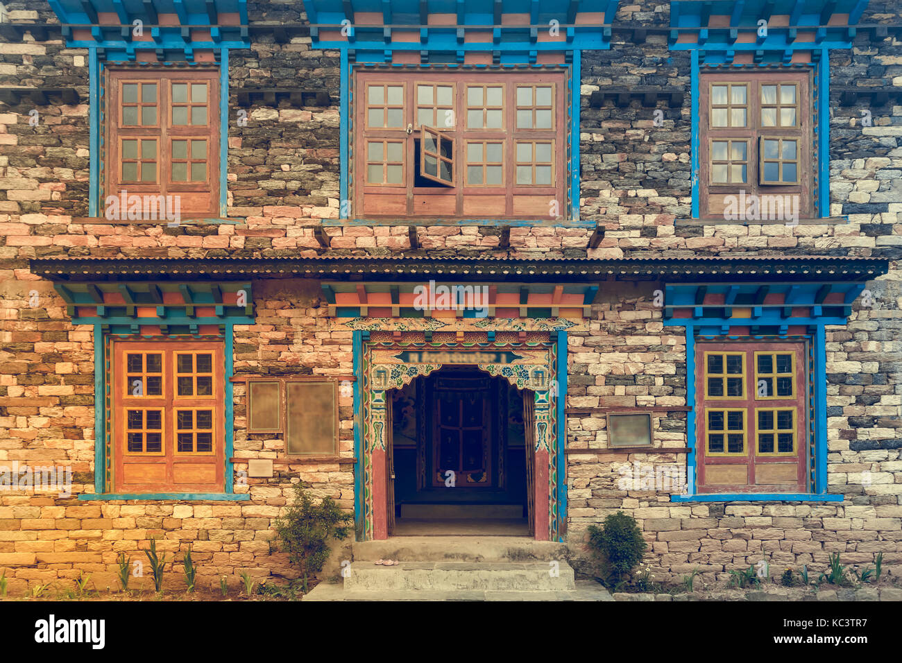 Nepal style windows and door in the old brick wall Stock Photo - Alamy