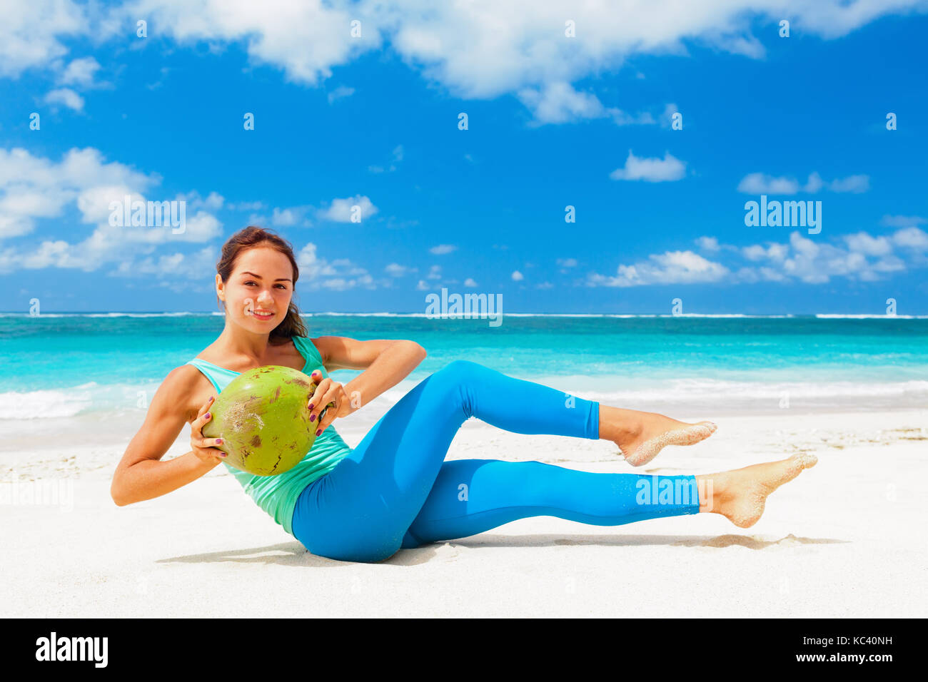 Young woman fitness abdominal exercise on beach to keep fit and health ...