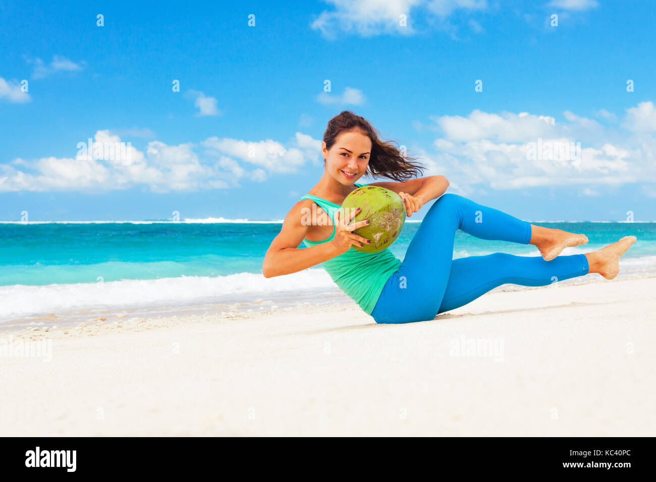 Young woman fitness abdominal exercise on sea beach to keep fit and ...