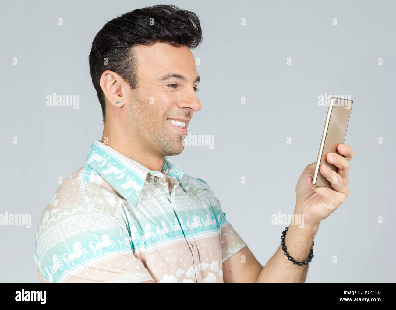 Man surfs the internet, uses digital media and smiles. He uses his cell ...