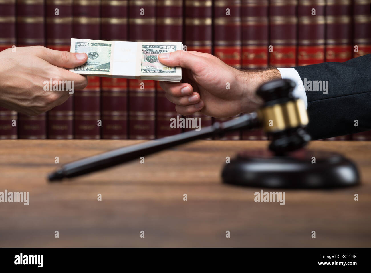Gavel on wooden table with judge taking bribe from businessman in ...