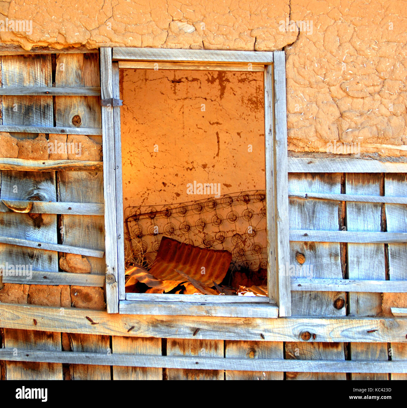 Window view shows inside of adobe home that has been abandoned. Old ...