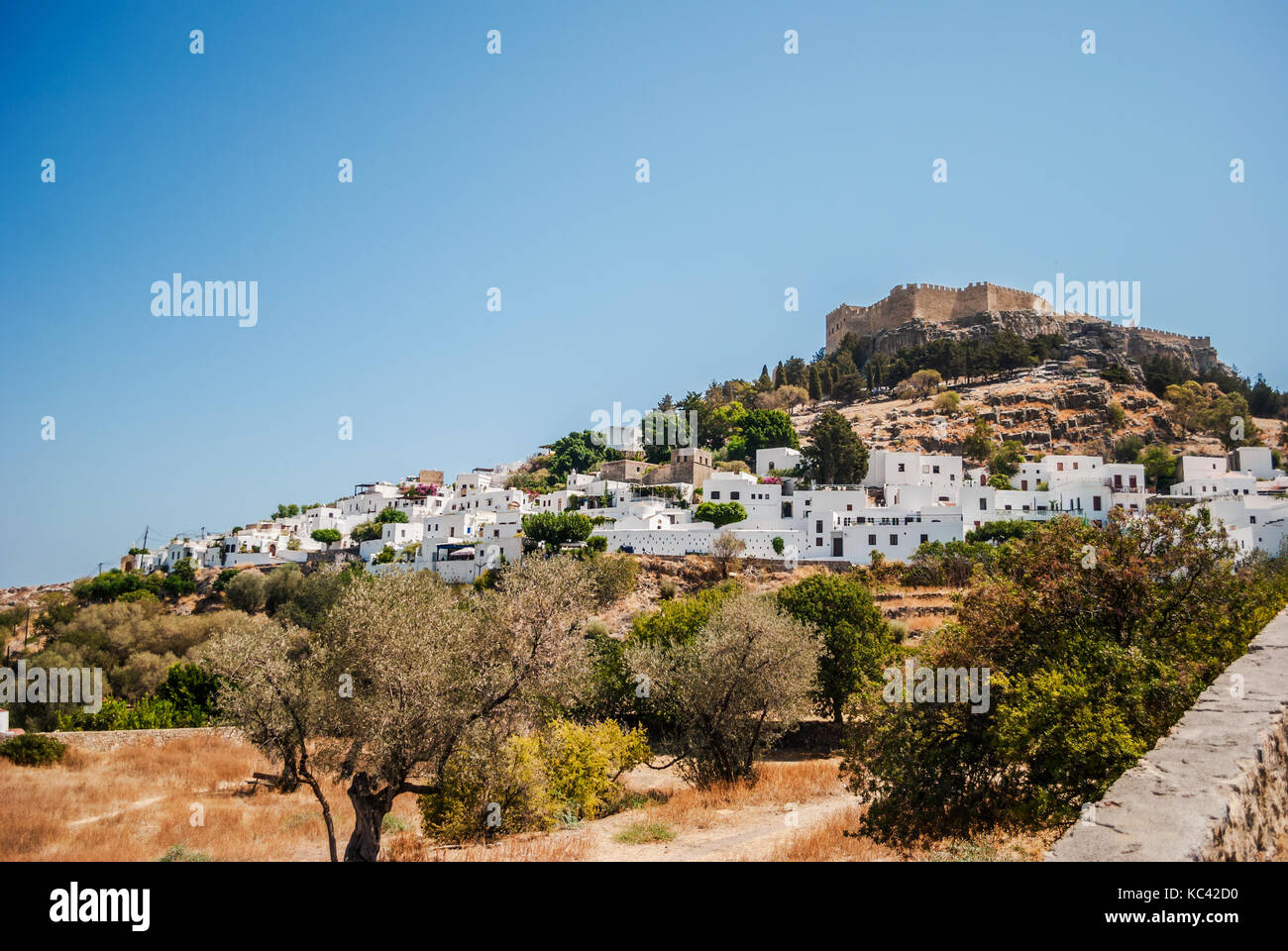 Medieval castle on Acropolis of Lindos with blue bay beneath, Rhodes ...