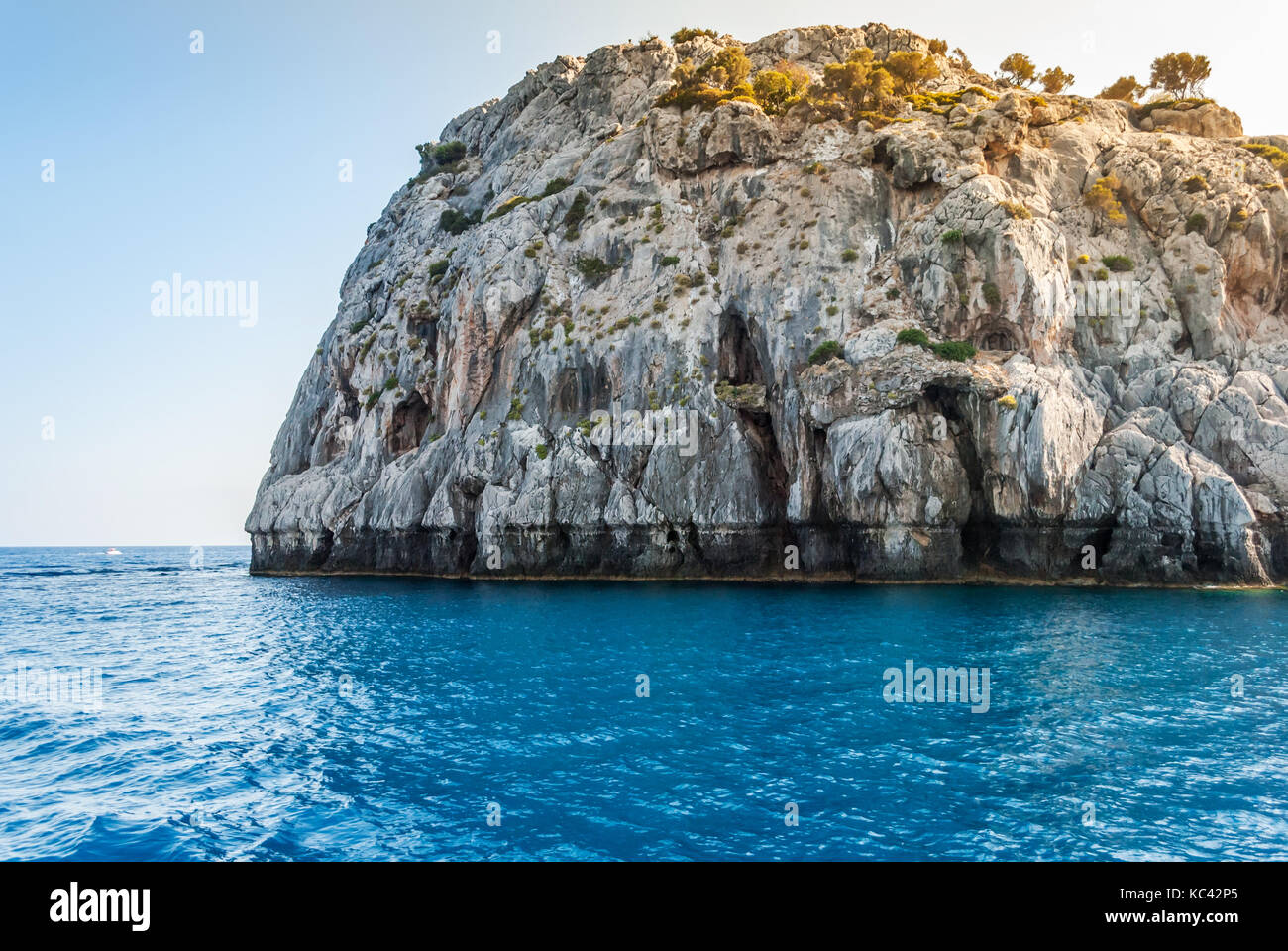 Blue sea and sharp rocks that surround it Stock Photo - Alamy