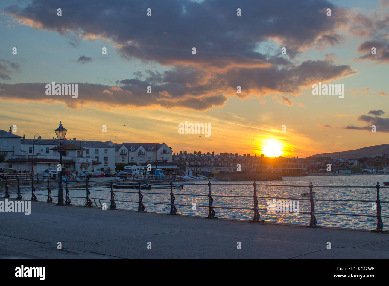 The setting sun cast golden sun glow over seafront of seaside town ...